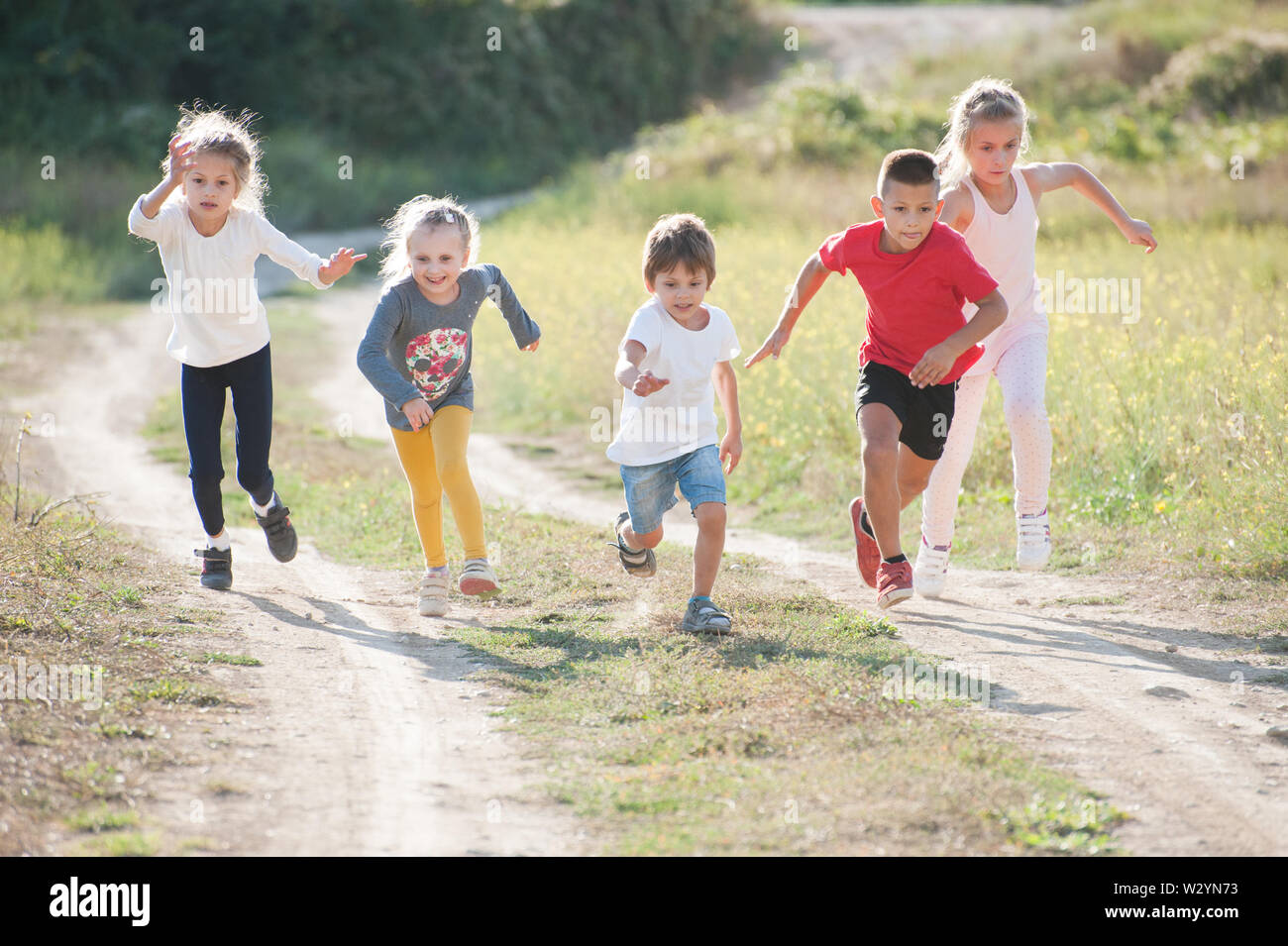 group of five little kids boys and girls running from start outdoor ...