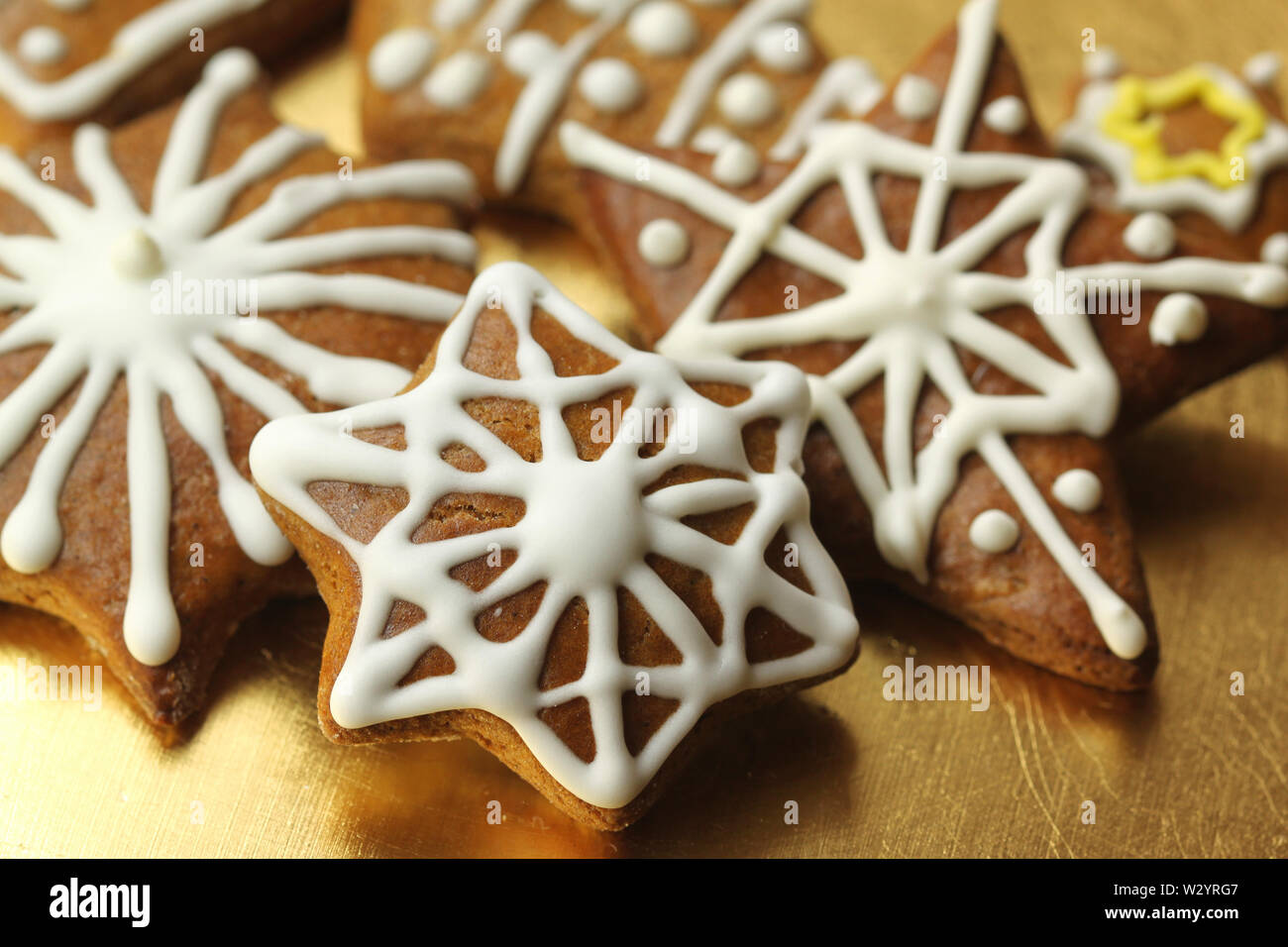 Gingerbread stars with icing decoration on golden plate Stock Photo - Alamy