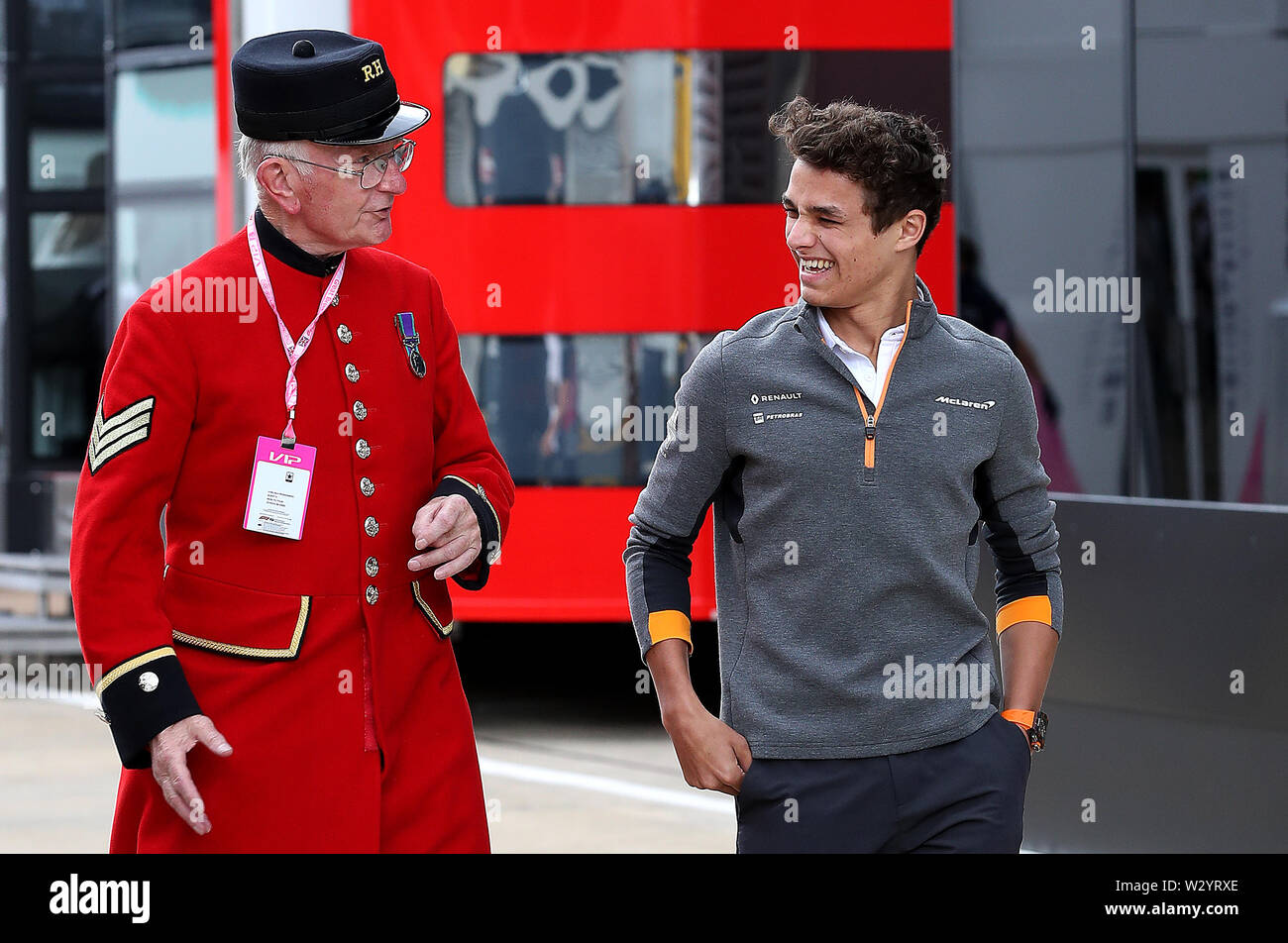McLaren driver Lando Norris (right) walks through the paddock with a ...
