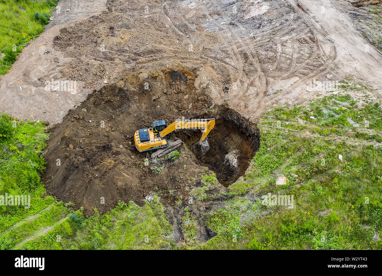 Aerial view of the excavator digging a large pit Stock Photo - Alamy