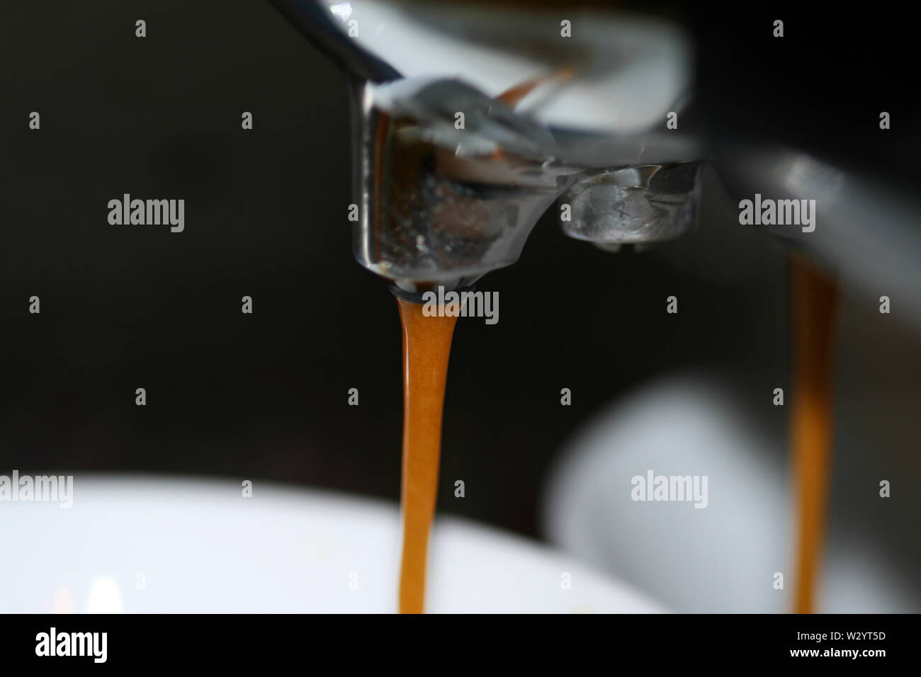 Streem of espresso coffee from working coffee machine Stock Photo - Alamy