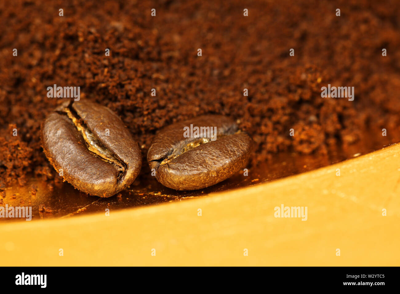 Two arabic coffee beans on ground coffee on golden plate Stock Photo ...