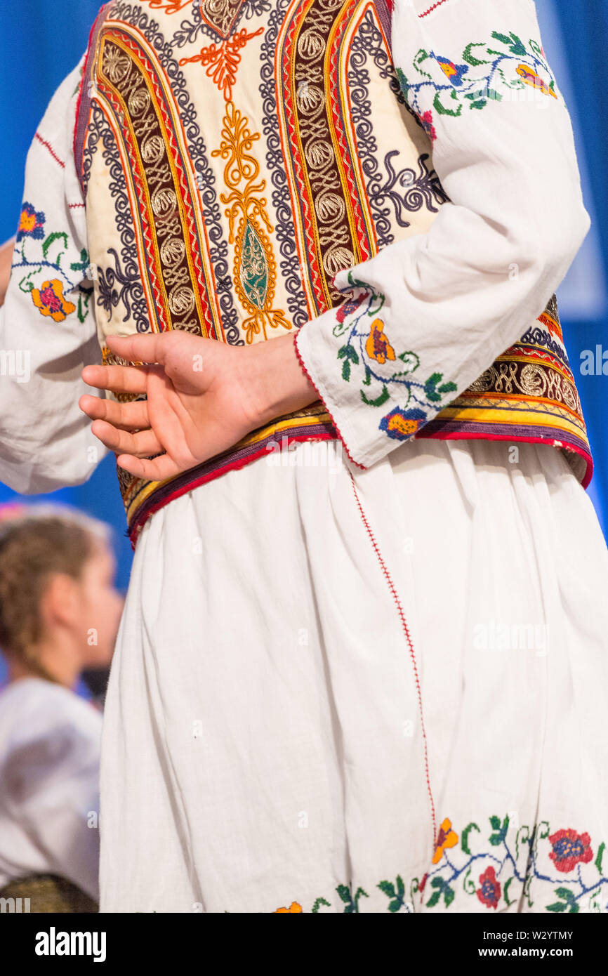 Young Romanian dancer hold hand on his back while perform a folk dance ...