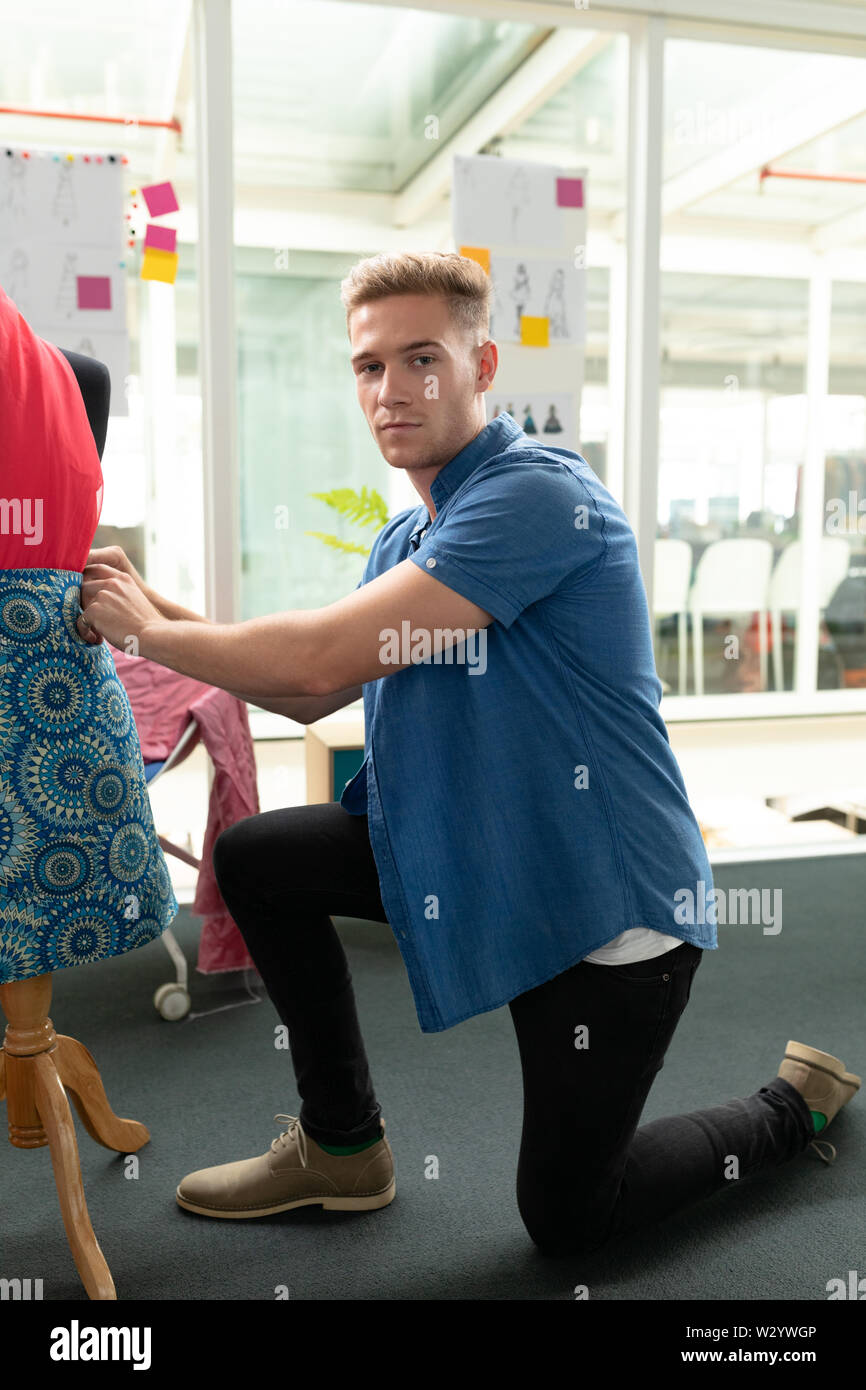 Male fashion designer dressing a mannequin in design studio Stock Photo ...