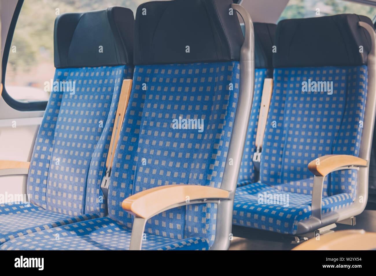 Rows of blue fabric seats with leather headrests inside empty modern ...