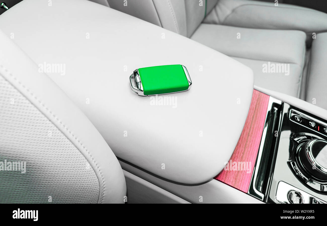 Closeup inside vehicle of wireless green leather key ignition on white ...
