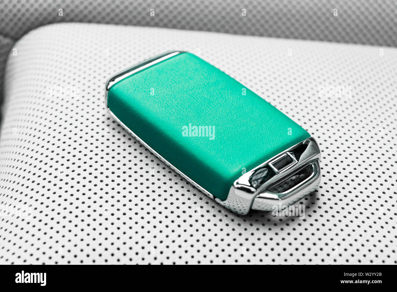 Closeup inside vehicle of wireless green leather key ignition on white ...