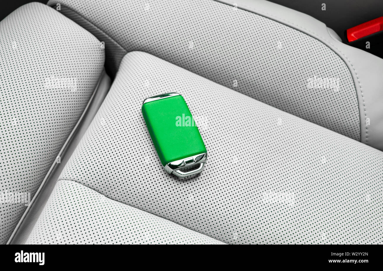Closeup inside vehicle of wireless green leather key ignition on white ...