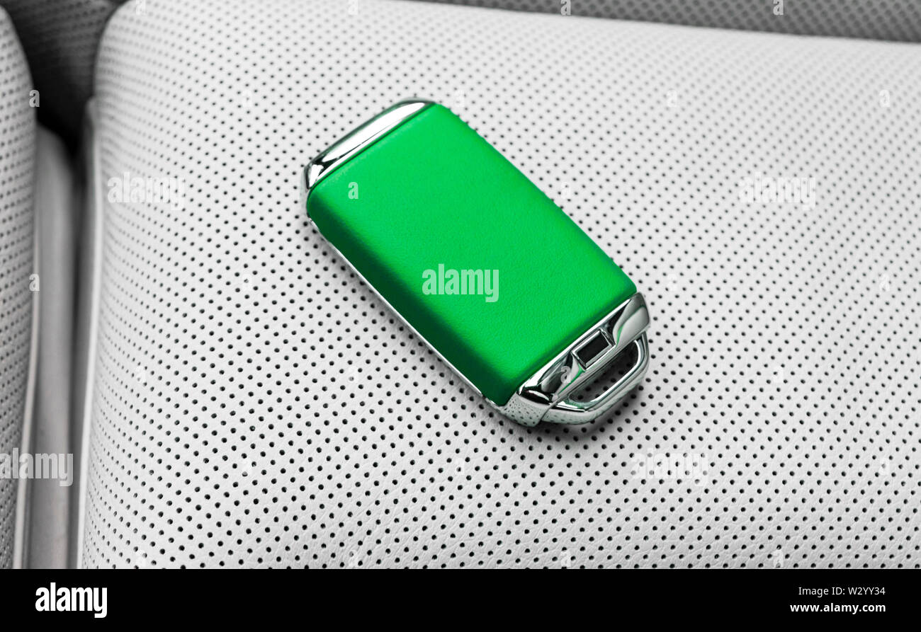 Closeup inside vehicle of wireless green leather key ignition on white ...