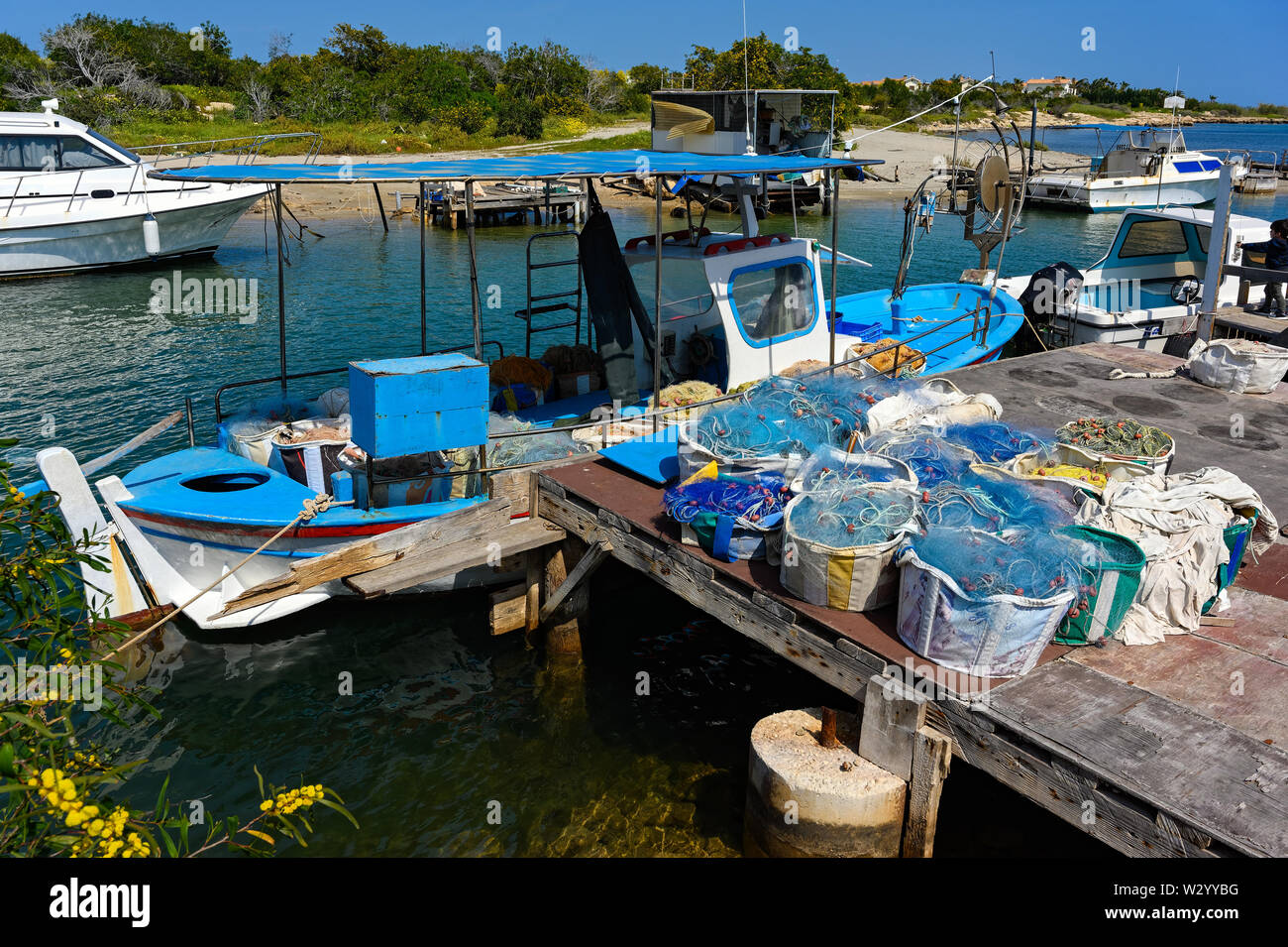 Traditional wooden boats and fishing nets in the harbor of Potamos in ...