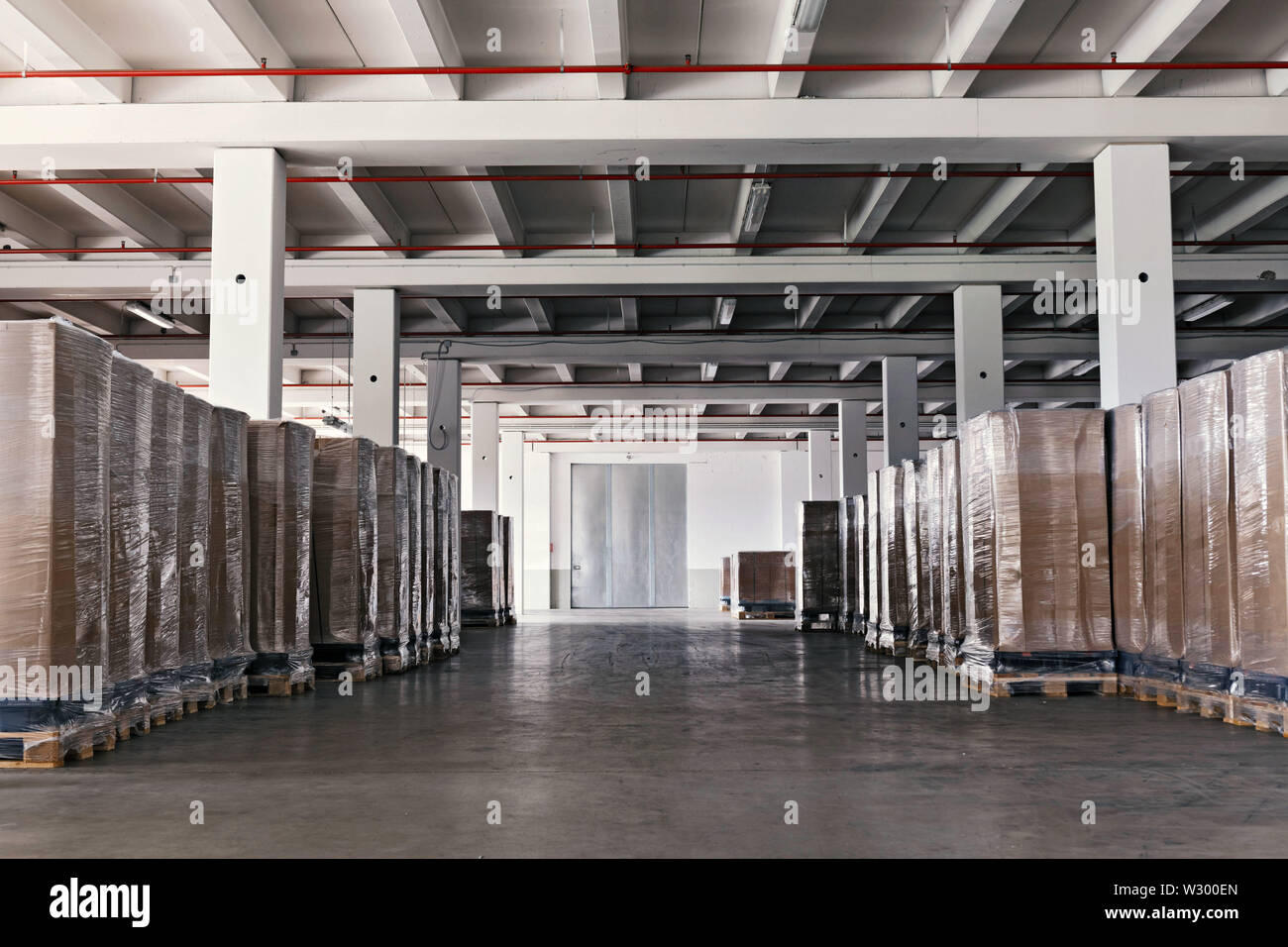 Warehouse with concrete floor and packed cartons neatly stacked on ...