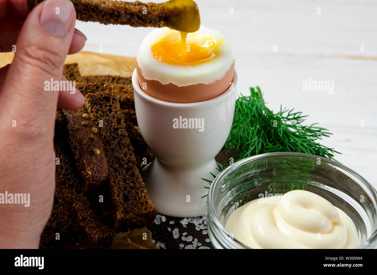 Healthy food. English breakfast with boiled egg and croutons on a white wood background. Healthy ...