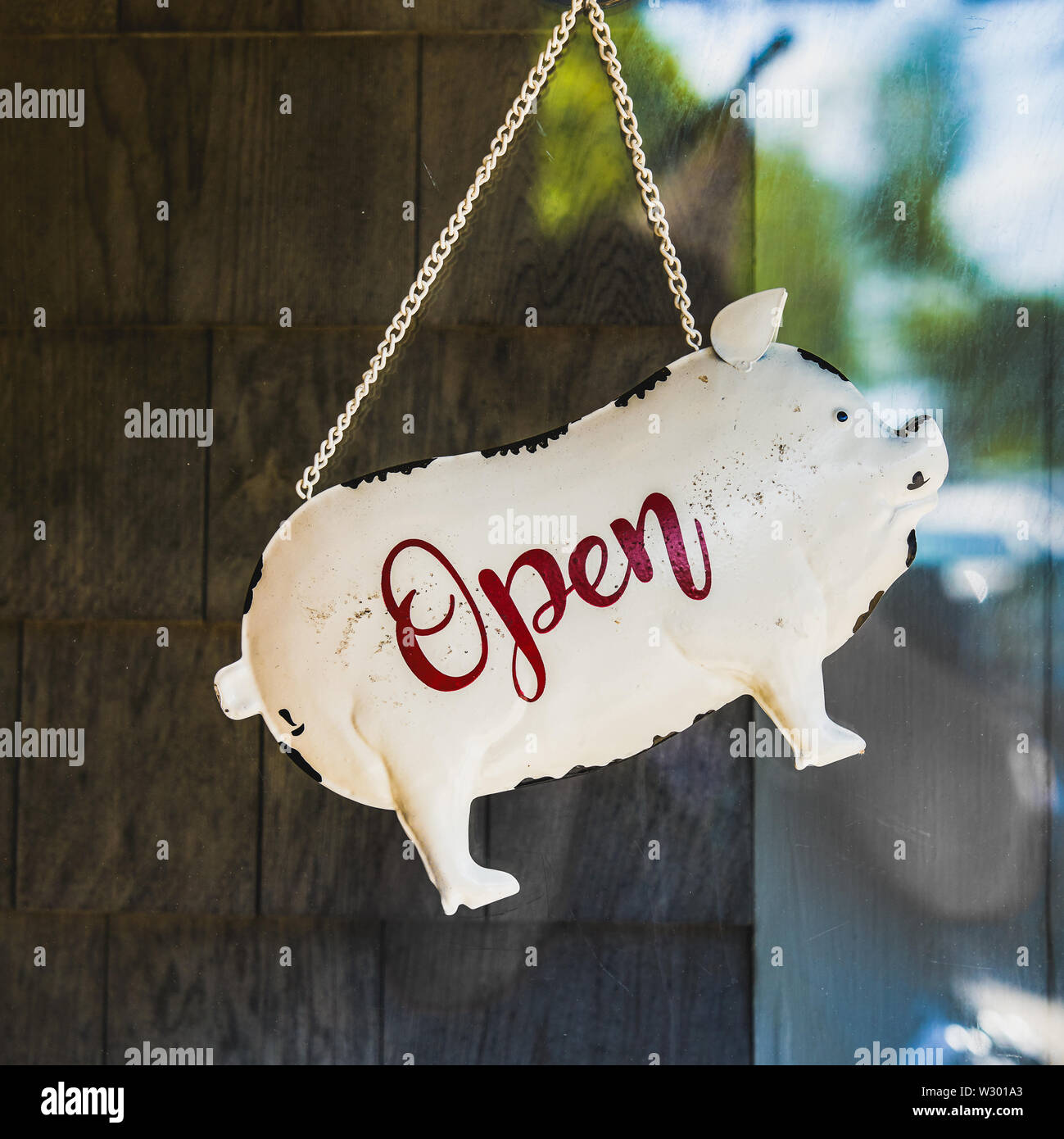 rustic pig shaped open sign hanging on a glass door Stock Photo - Alamy