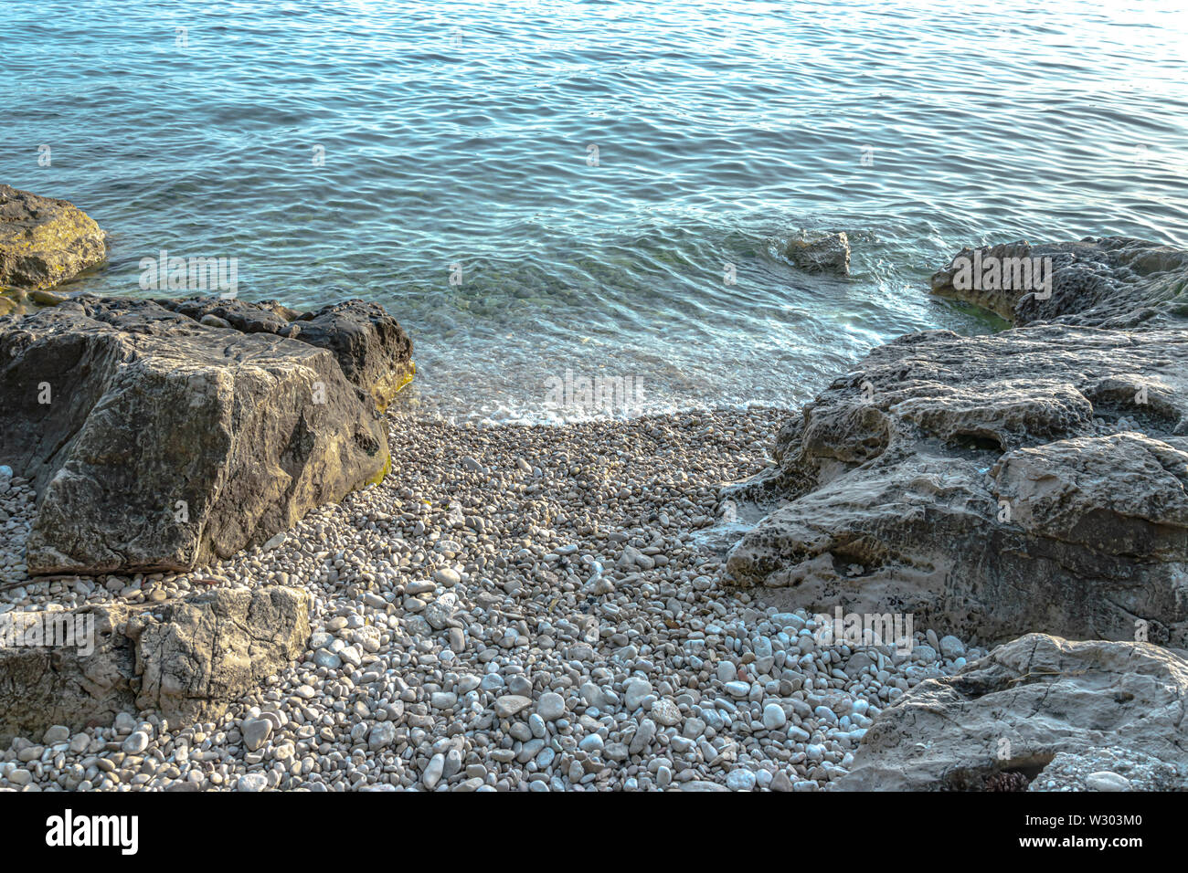 Gravel beach and shallow sea Stock Photo - Alamy