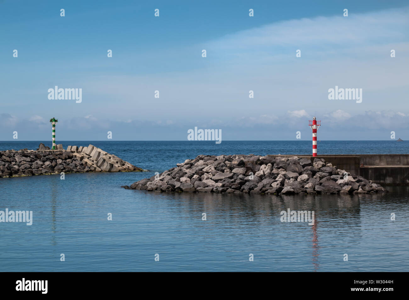 Entrance to the port separated by a stone wall with two columns, green ...