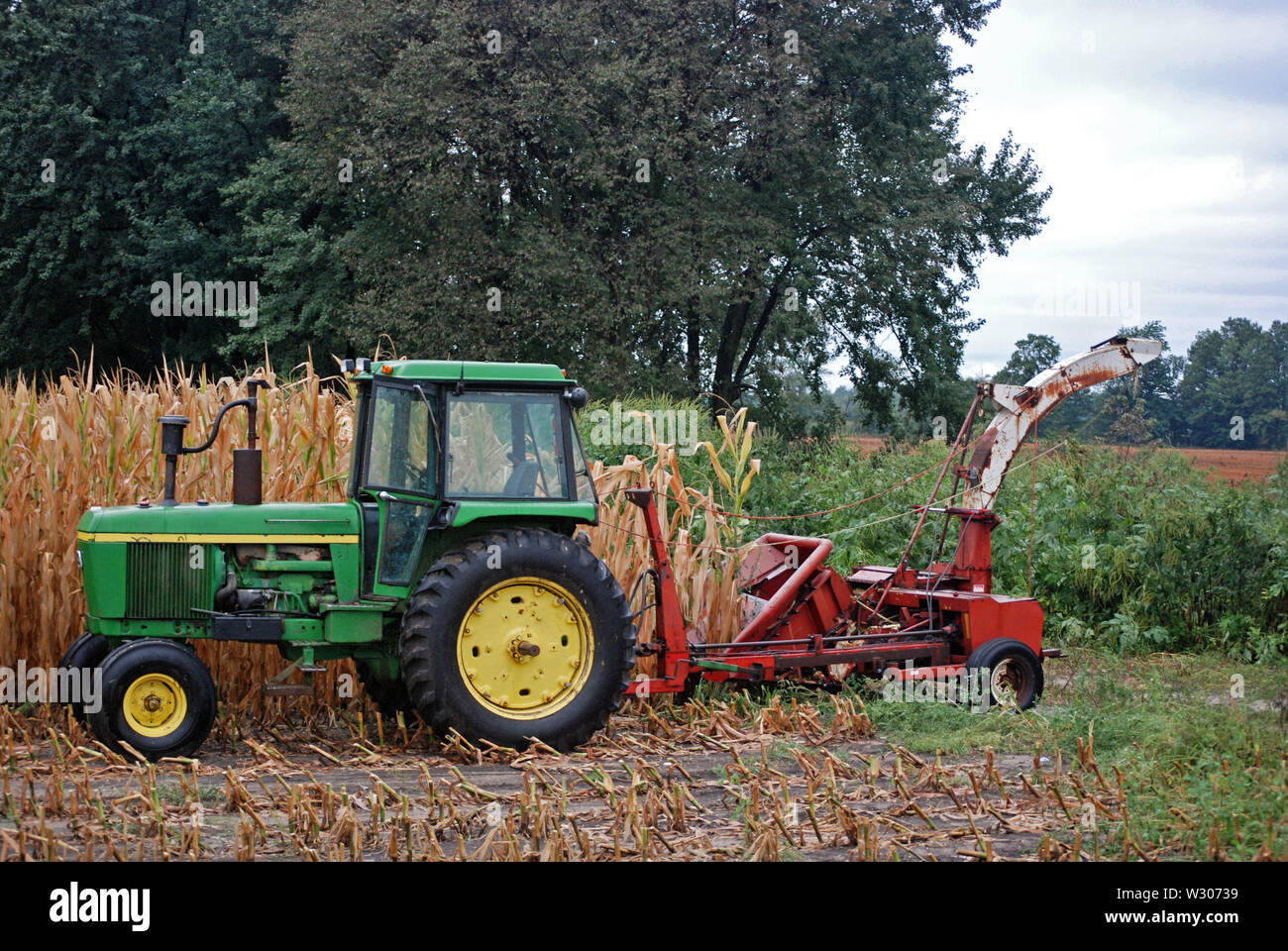Green farm tractor with harvester in Michigan cornfield Stock Photo - Alamy
