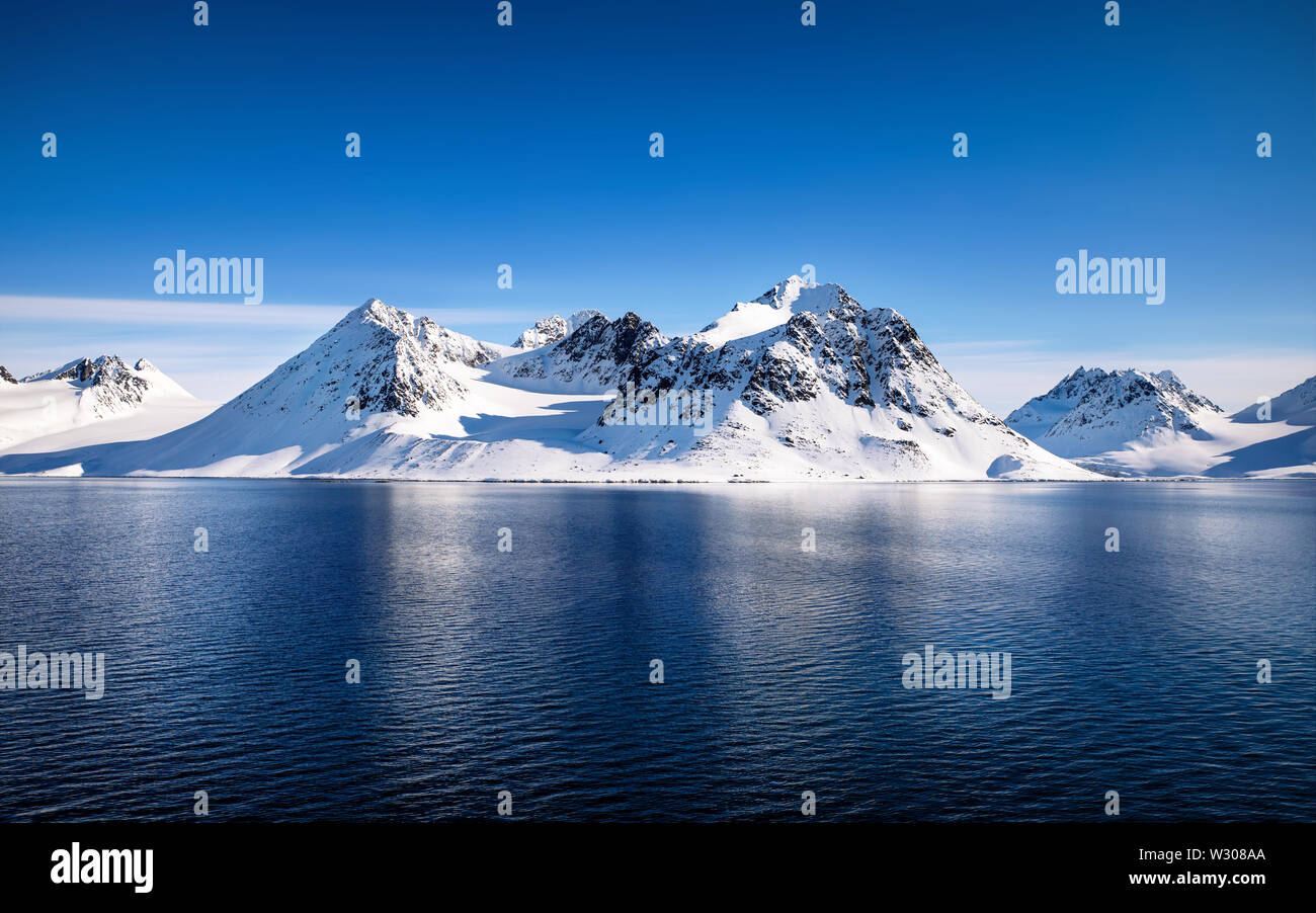 Blue sky, blue and snowy mountains in the beautiful fjords of Svalbard ...