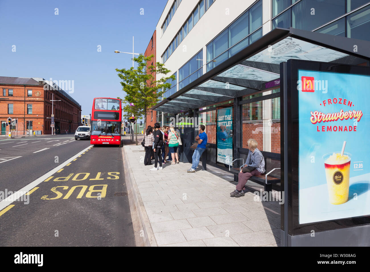 Ireland, North, Belfast, Titanic Quarter, Tourists at bus stop awaiting ...