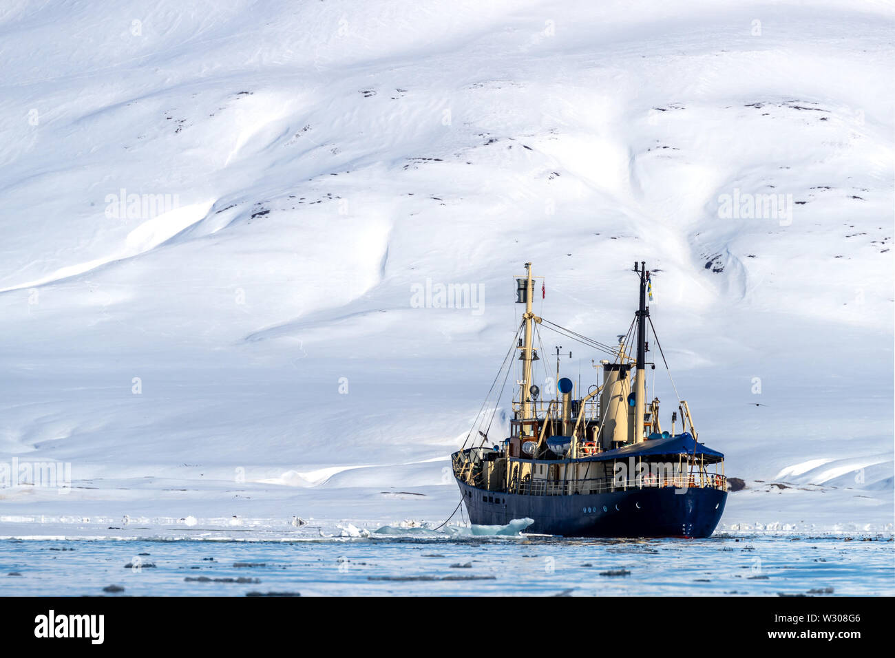 Icebreaker ship going through the fast ice of the fjords of Svalbard, a ...