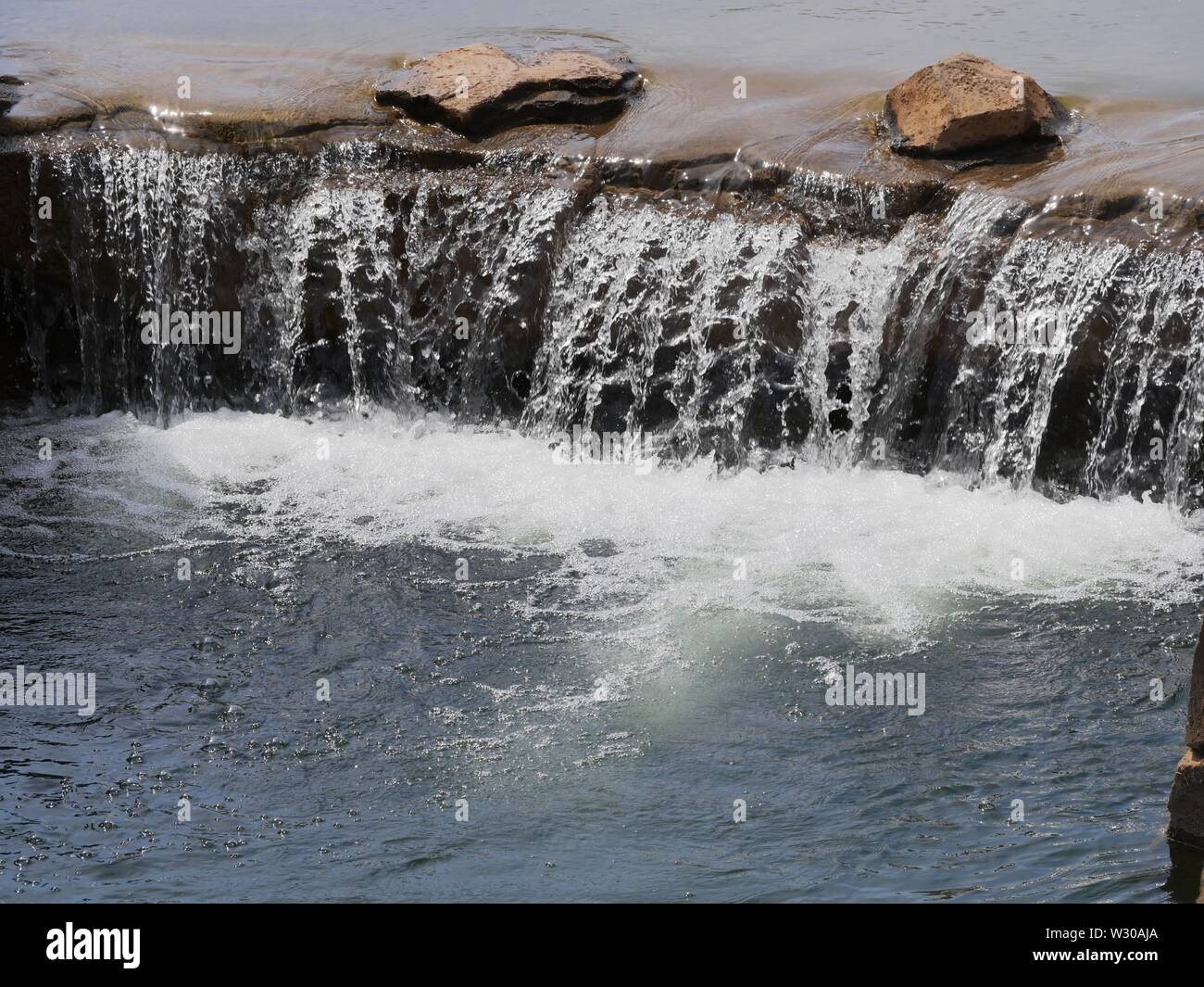 Small waterfall with water flowing in ripples in a river Stock Photo ...