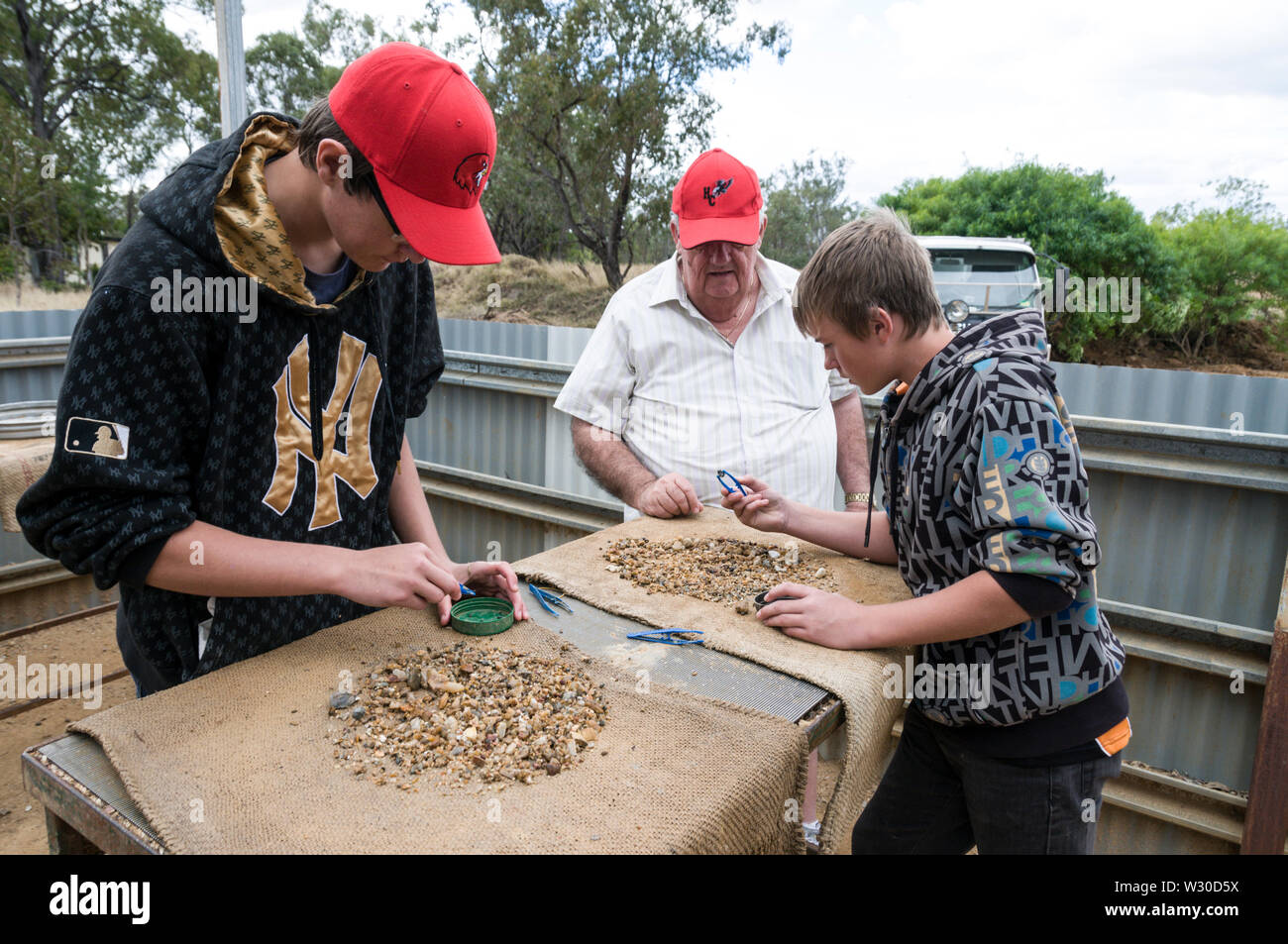 Visitors panning for any signs of blue stone sapphires at a gem shop ...