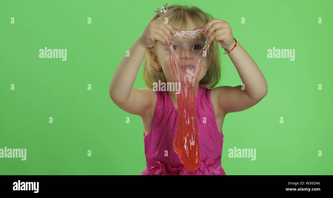 Child having fun making red slime. Kid playing with hand made toy slime ...