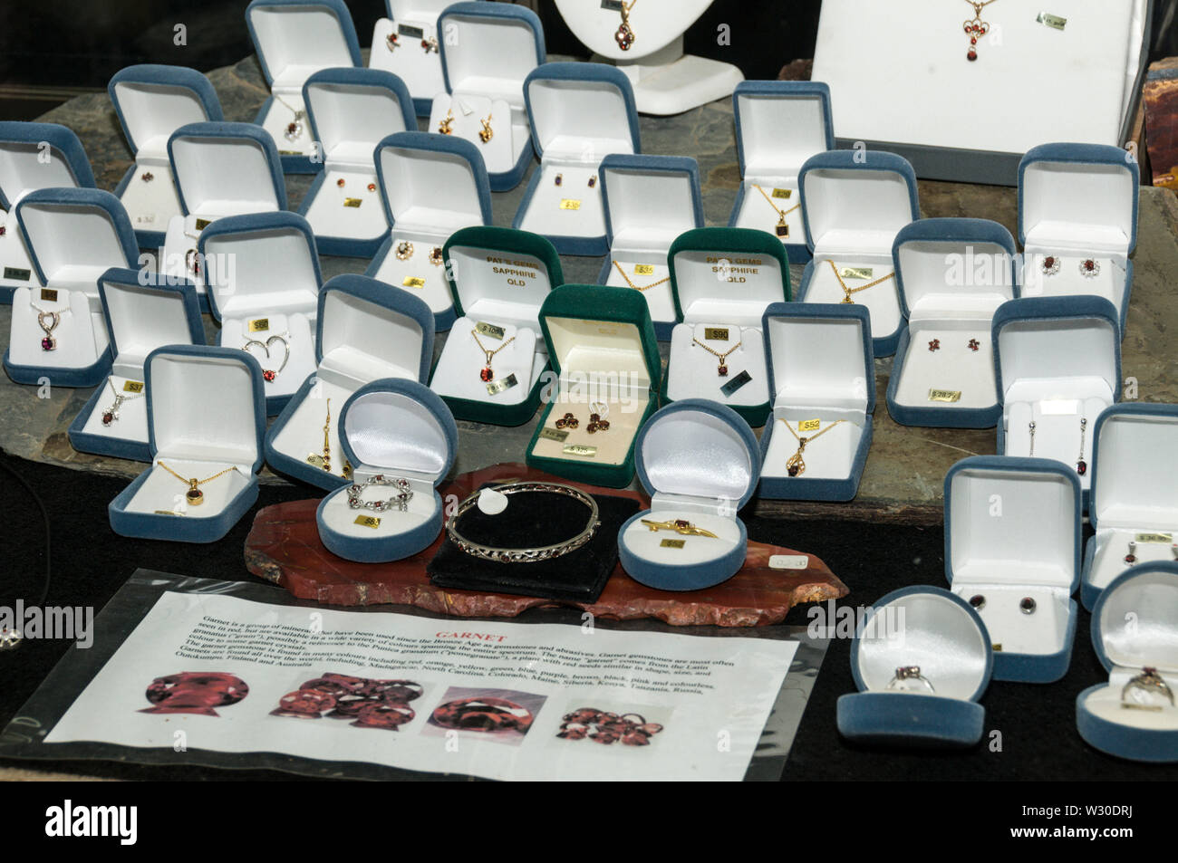 A shop display case of earrings, necklaces and rings with various local ...