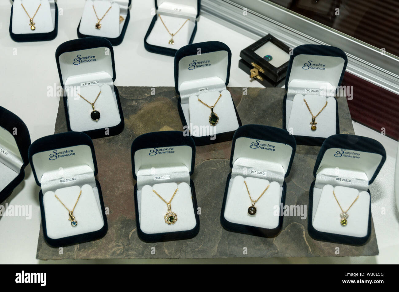 A shop display case of earrings, necklaces and rings with various local ...