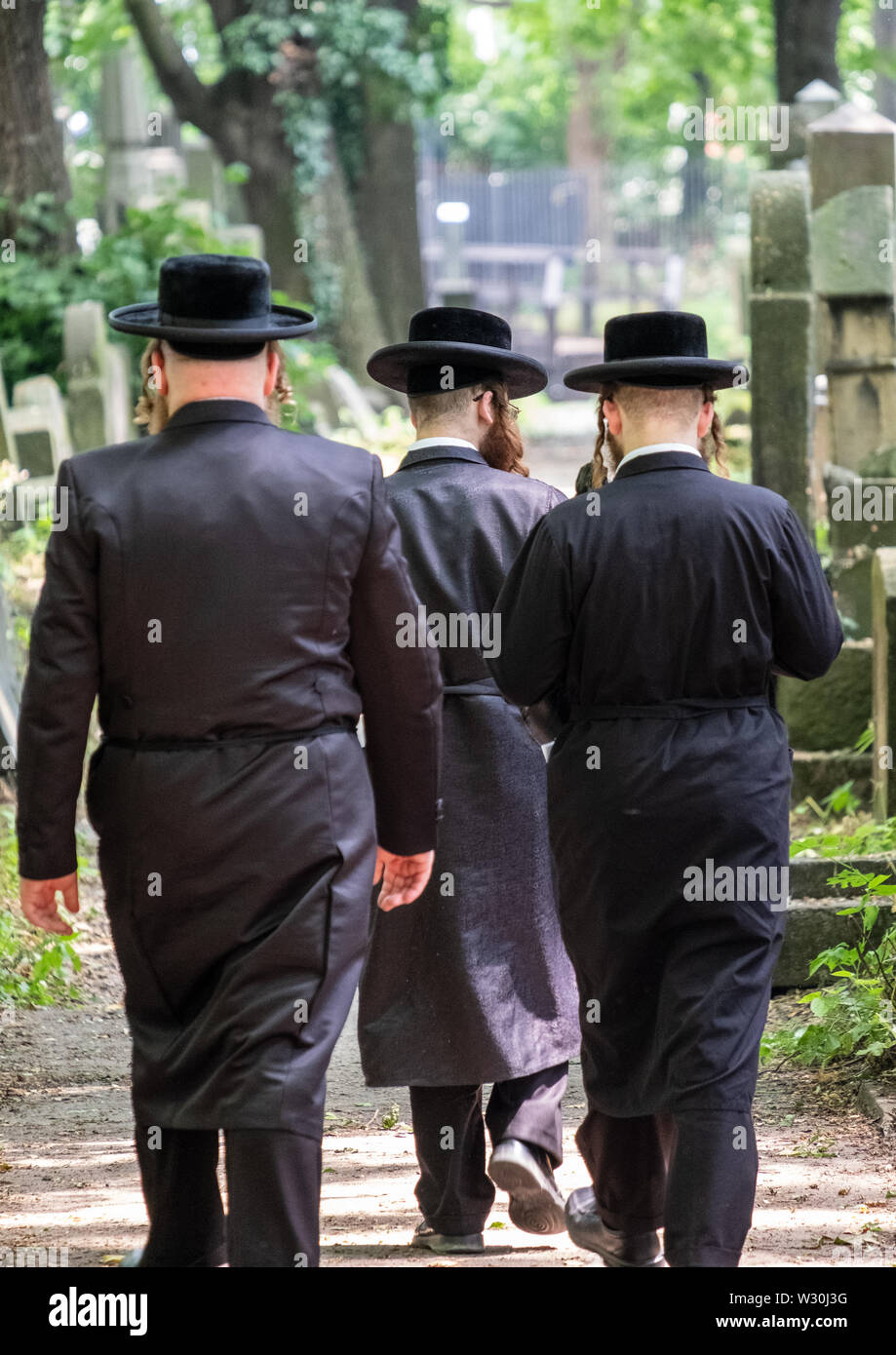 Jewish Chasidic men in traditional long black coats and hats say a ...