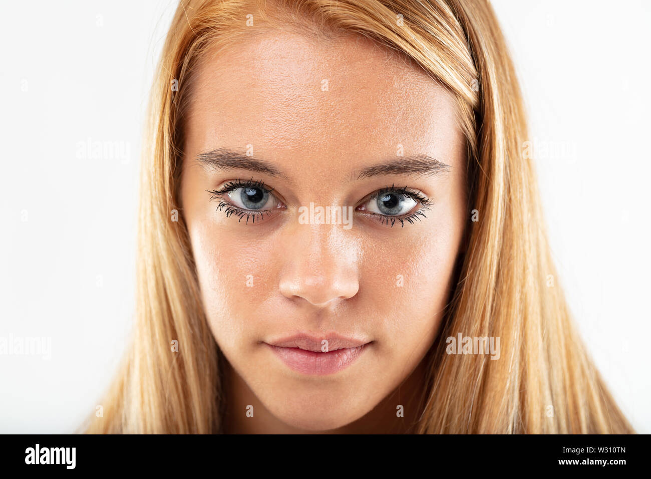 Attractive young teenage girl with long straight blond hair staring ...