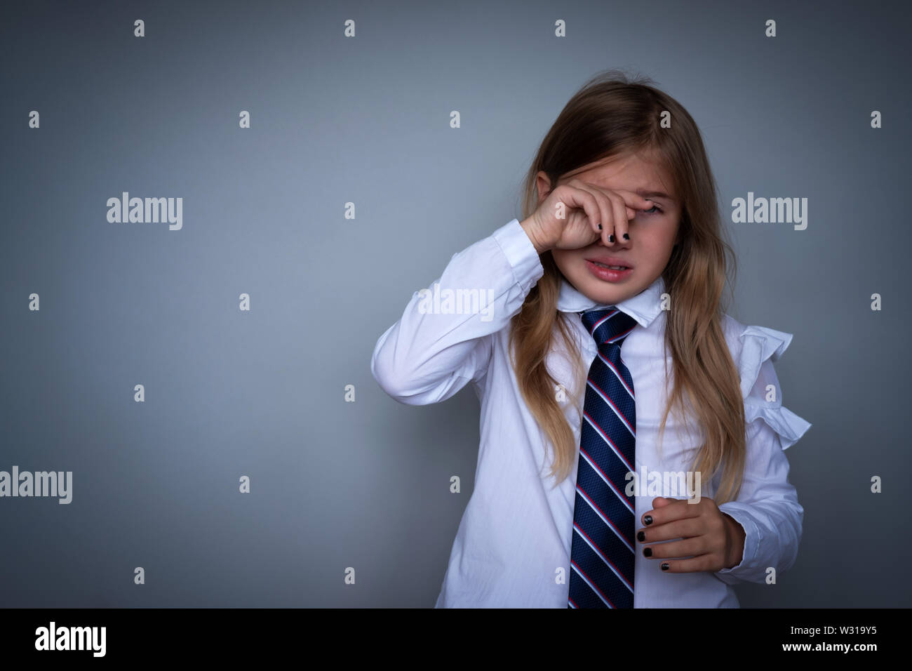 Small schoolgirl covering face, crying portrait. Preteen stressed ...