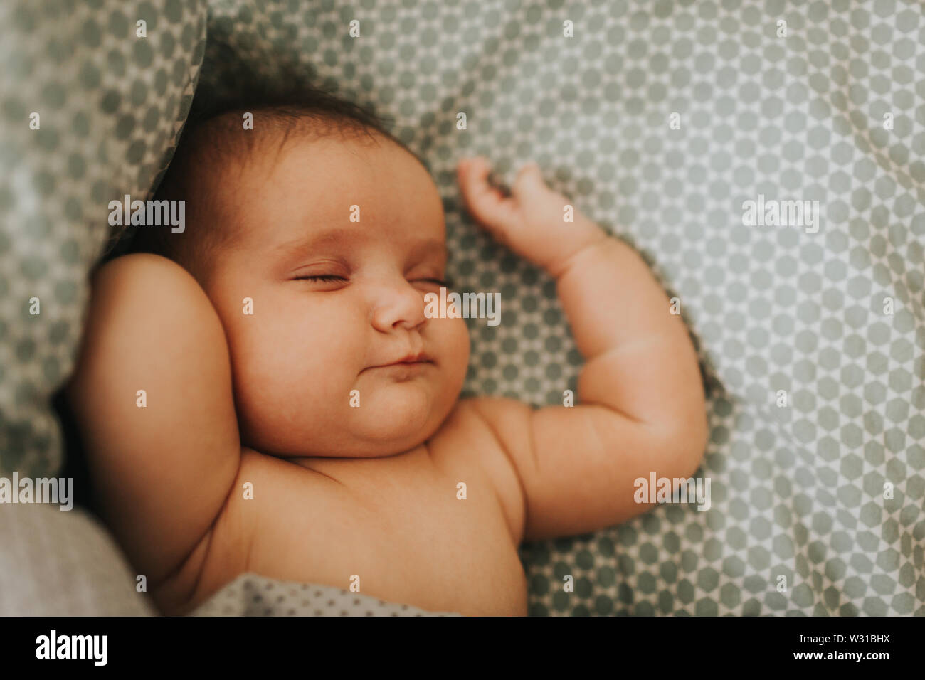 Close up image of 3 month baby stretching in her sleep Stock Photo - Alamy
