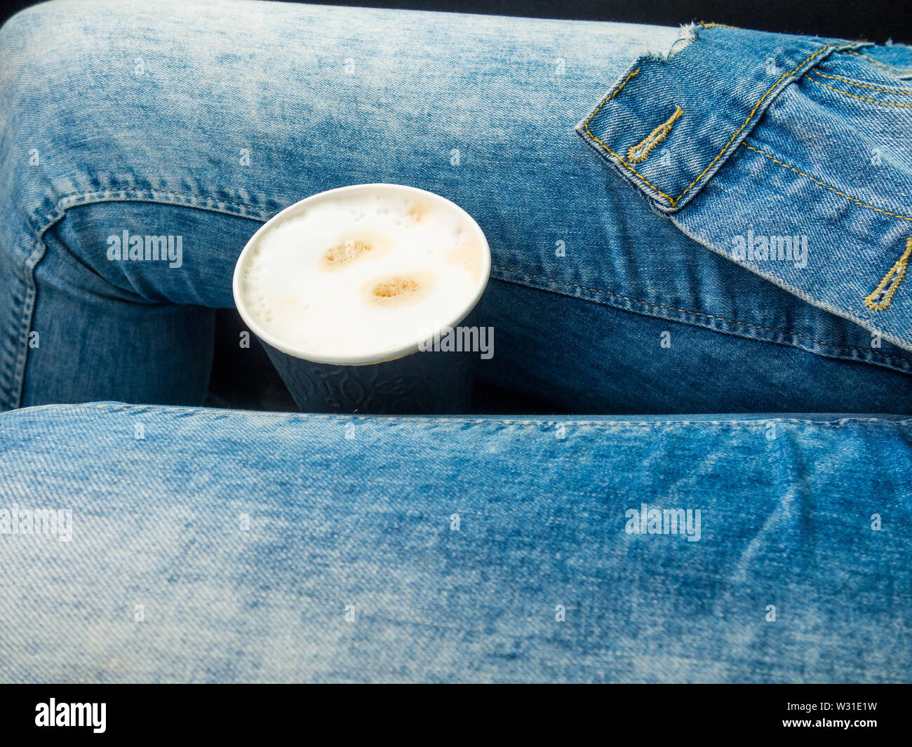 Young drinking coffee take away with legs in blue jeans on car - Travel ...