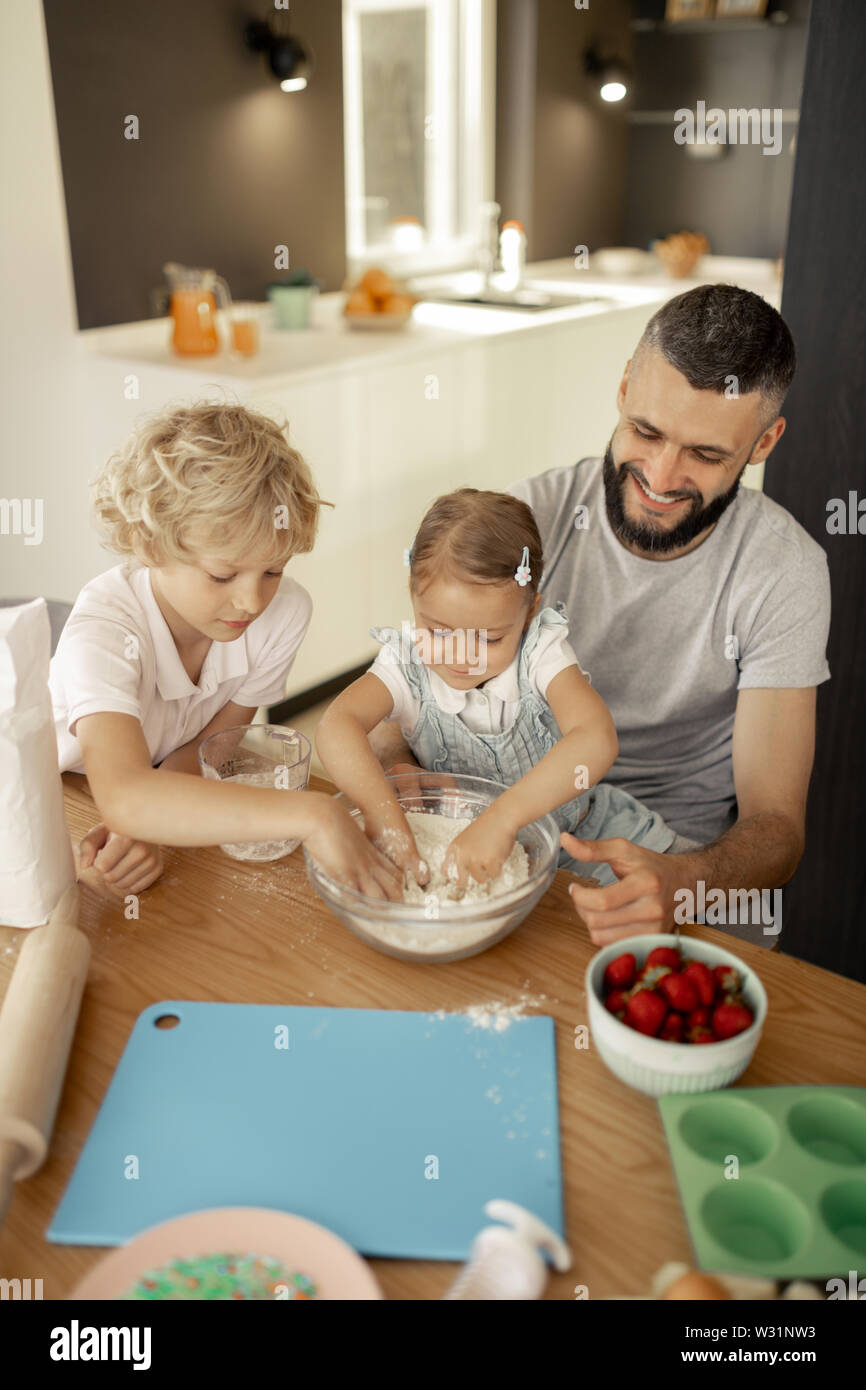 Time for cooking. Top view of positive nice family sitting at the table ...