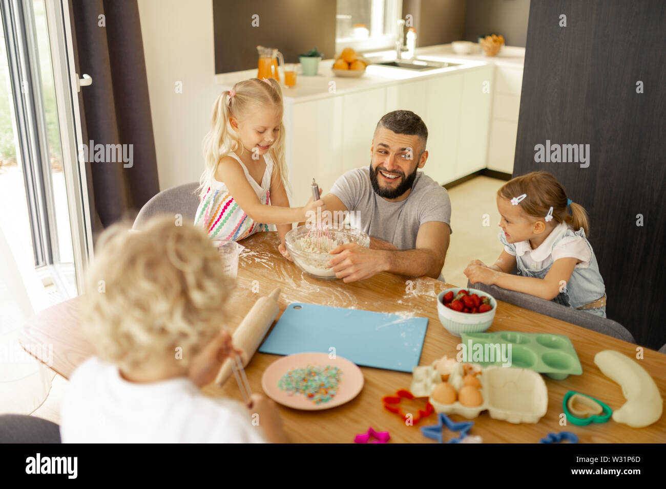 Funny activity. Delighted positive children having fun in the kitchen ...