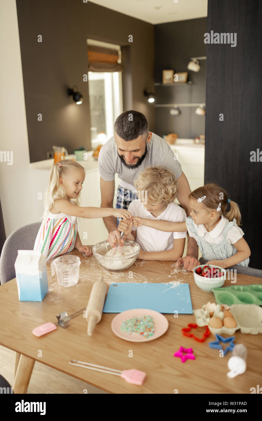 Cooking together. Joyful nice children helping each other in the ...
