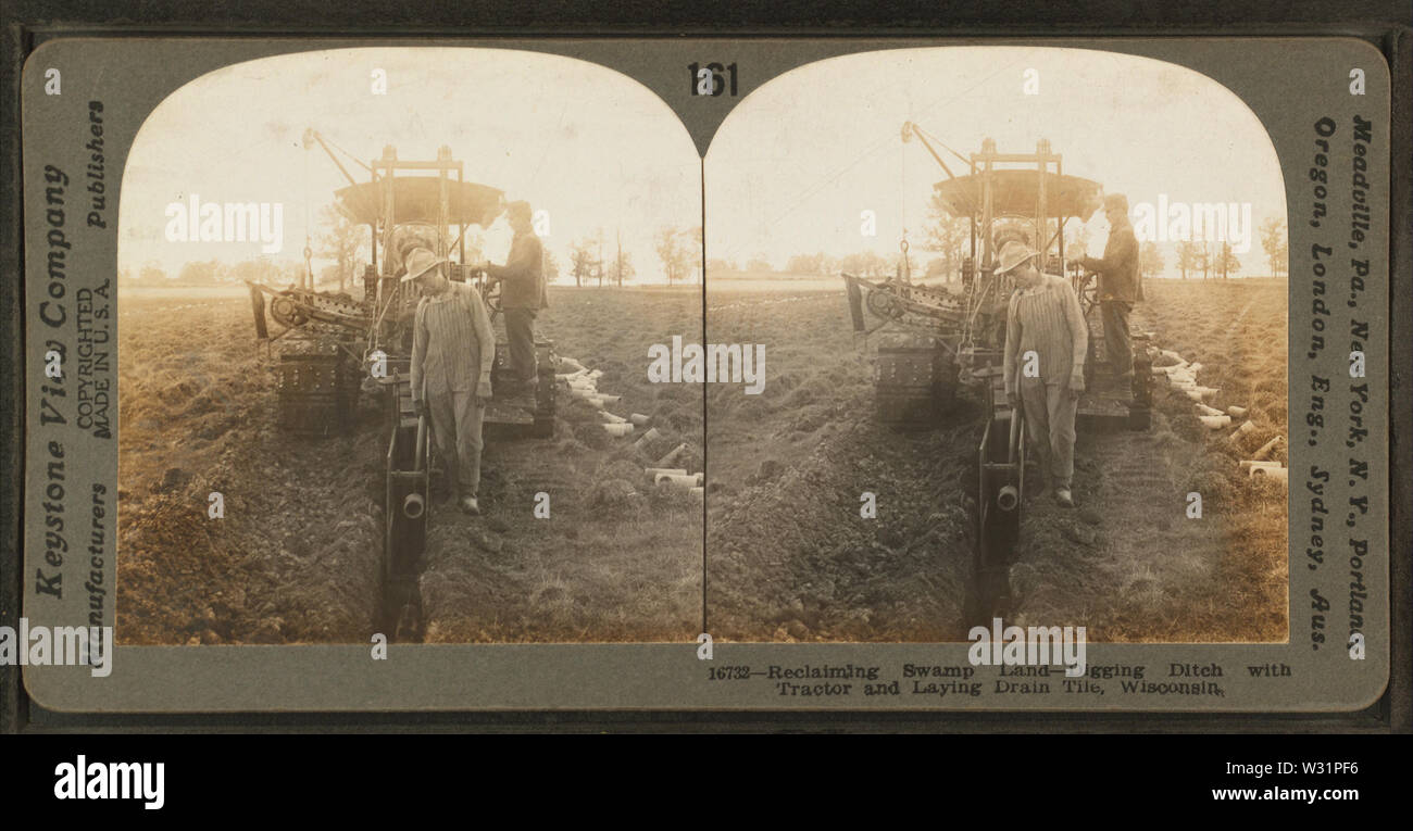 Reclaiming swamp land Digging ditch with tractor, and laying drain tile ...