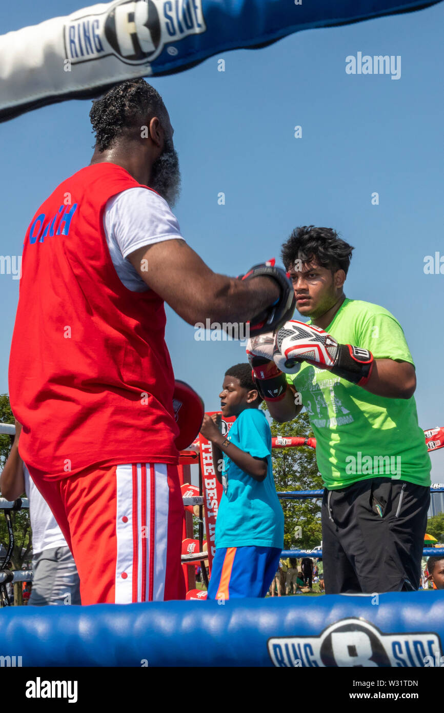 Detroit, Michigan - A coach (red shirt) gives a young man a boxing ...