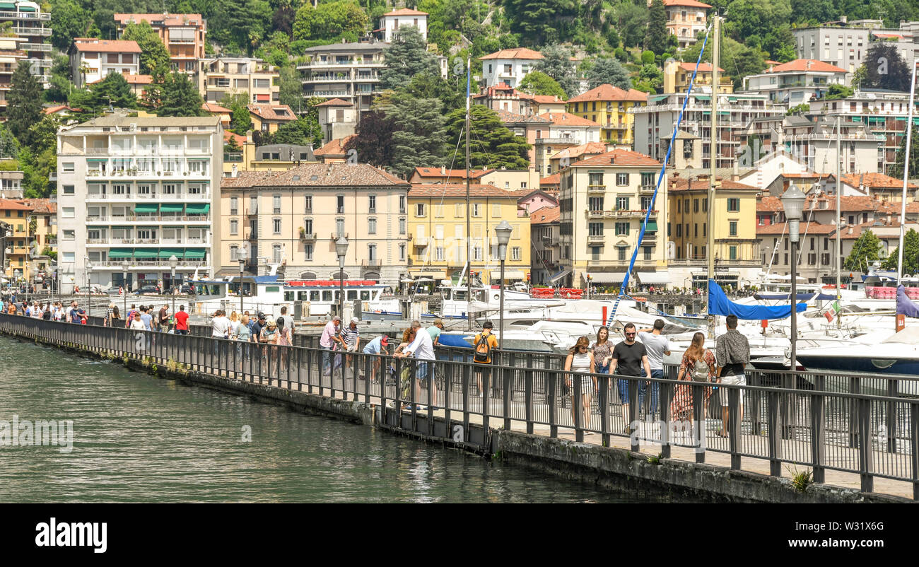 COMO, ITALY - JUNE 2019: People walking on the walkway which extends ...