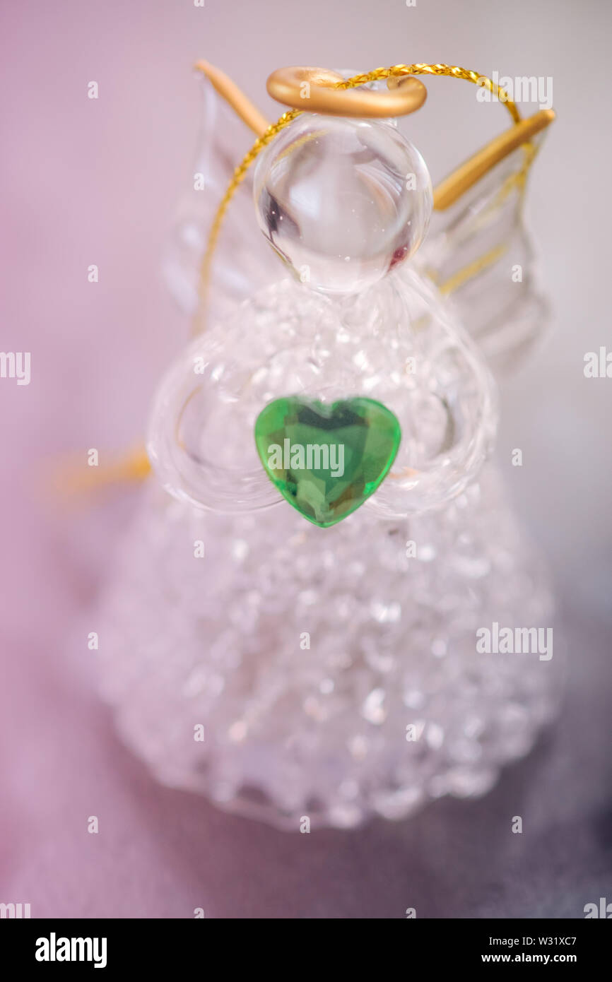 One small glass angel statuette with heart Stock Photo - Alamy