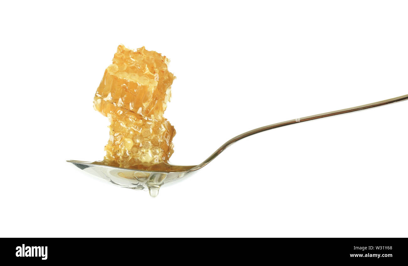 Close of piece of honeycomb on a spoon, isolated on white background ...