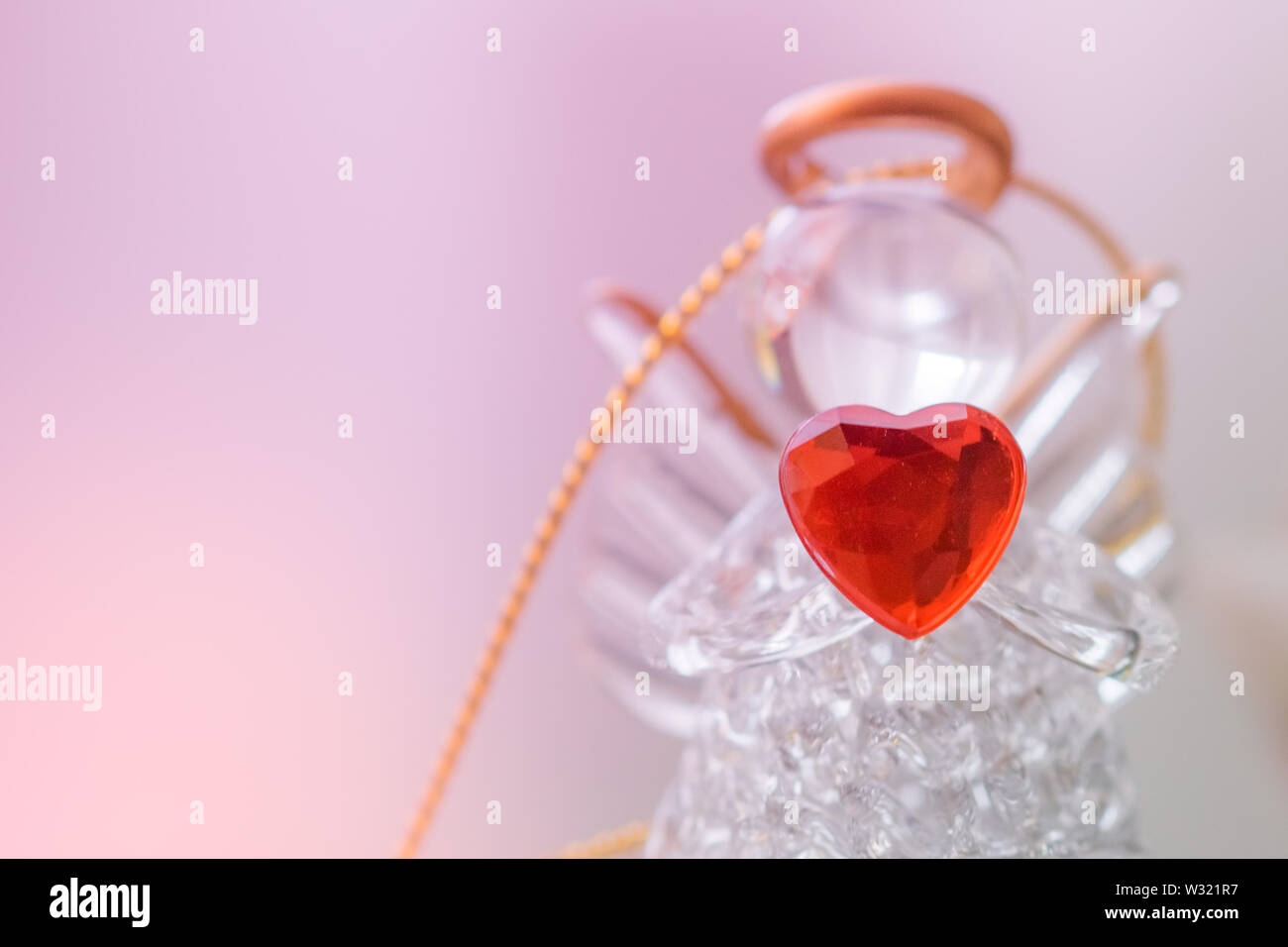 small glass angel statuette with red heart Stock Photo - Alamy