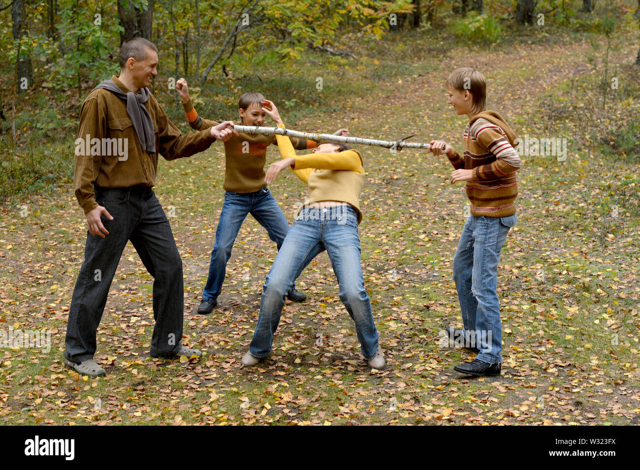 Family of four having fun in forest Stock Photo - Alamy