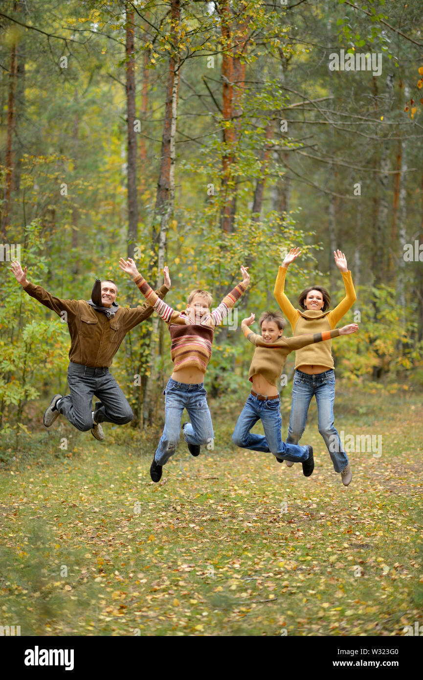 Family of four having fun in forest Stock Photo - Alamy