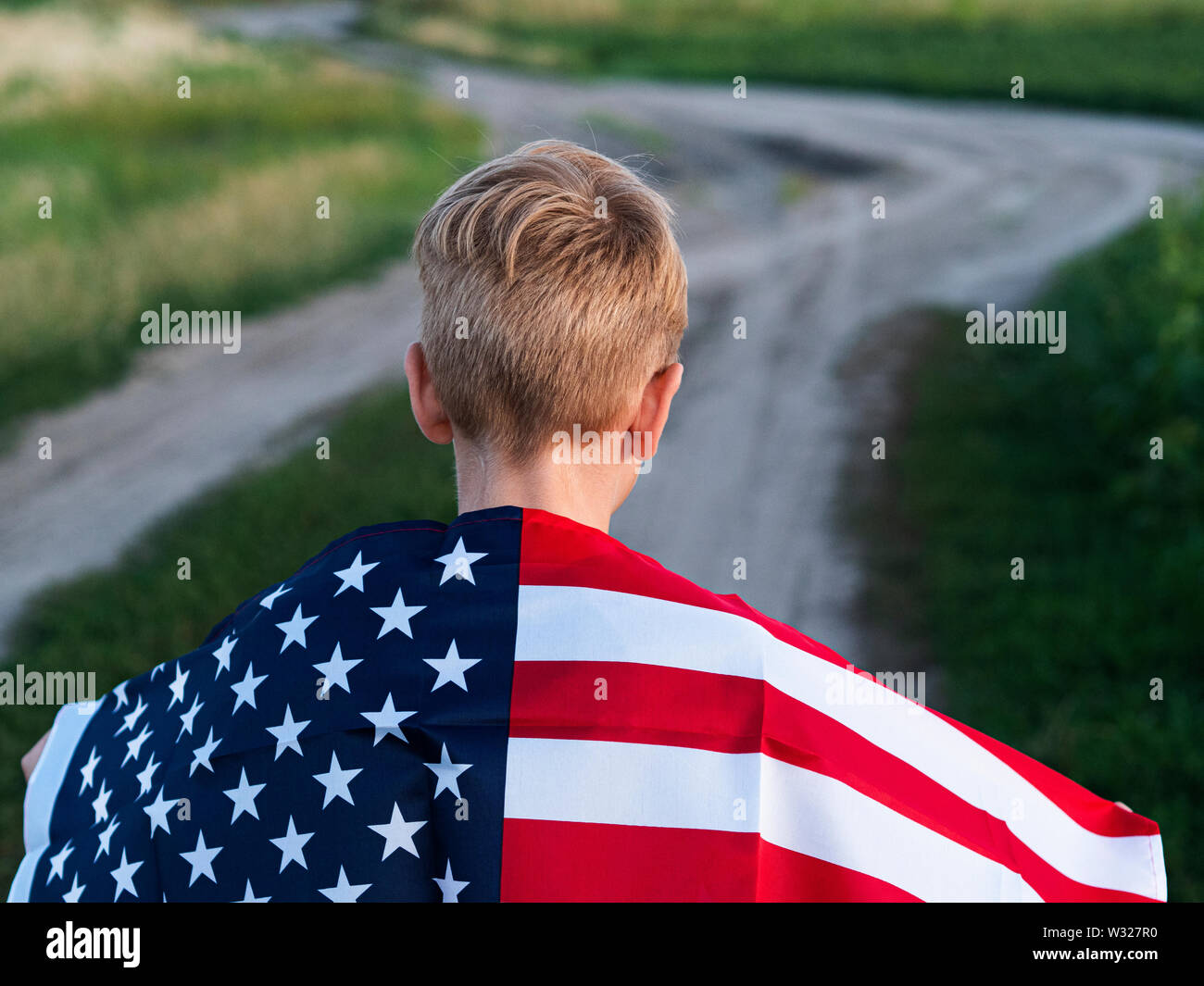 Caucasian Boy With A Us Flag Thrown Over His Back Stock Photo - Alamy