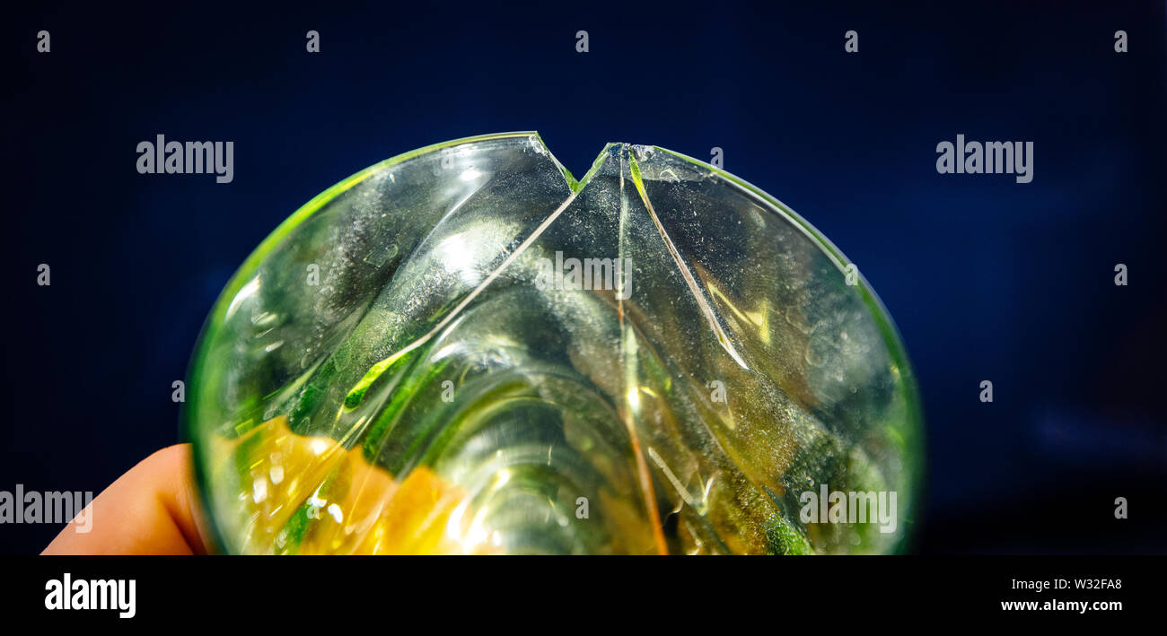 Man hand holding broken glass isolated light back background - close-up ...