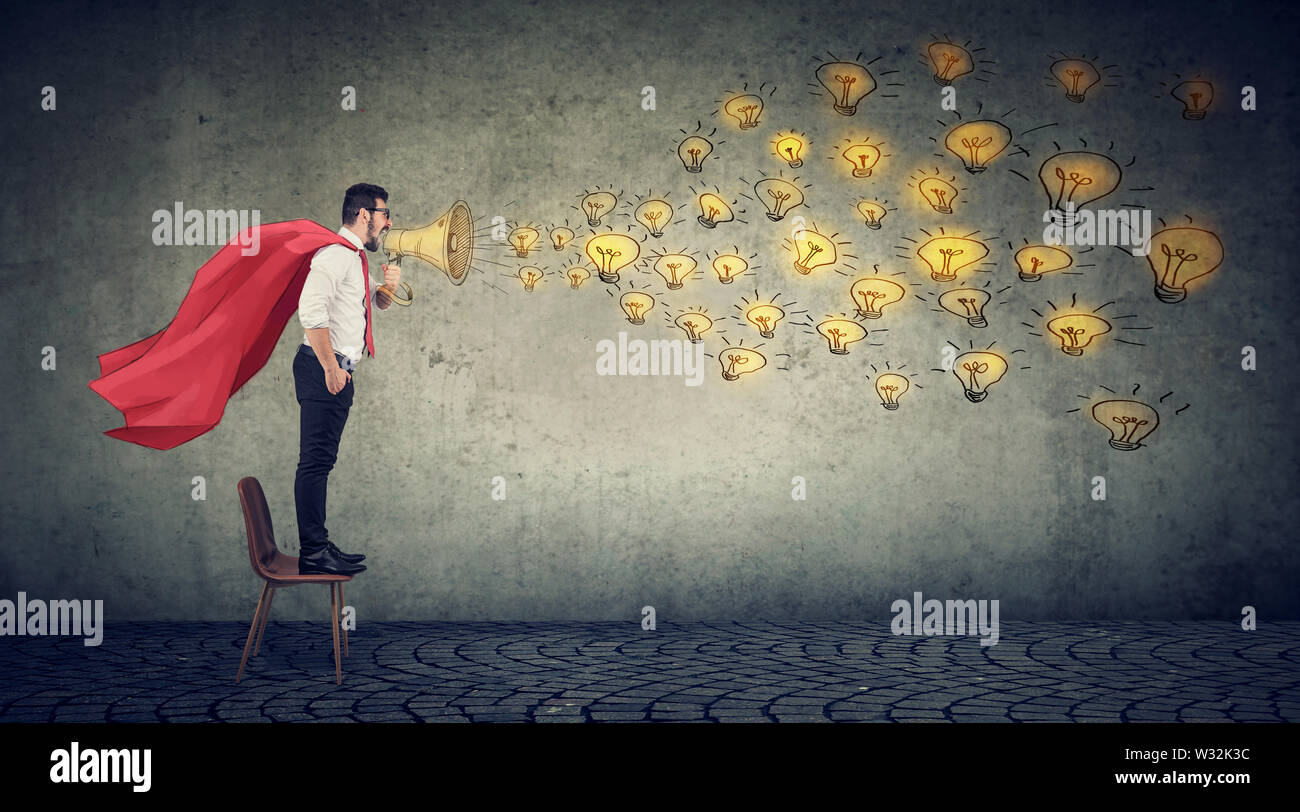 Young super hero business man standing on a chair screaming in ...