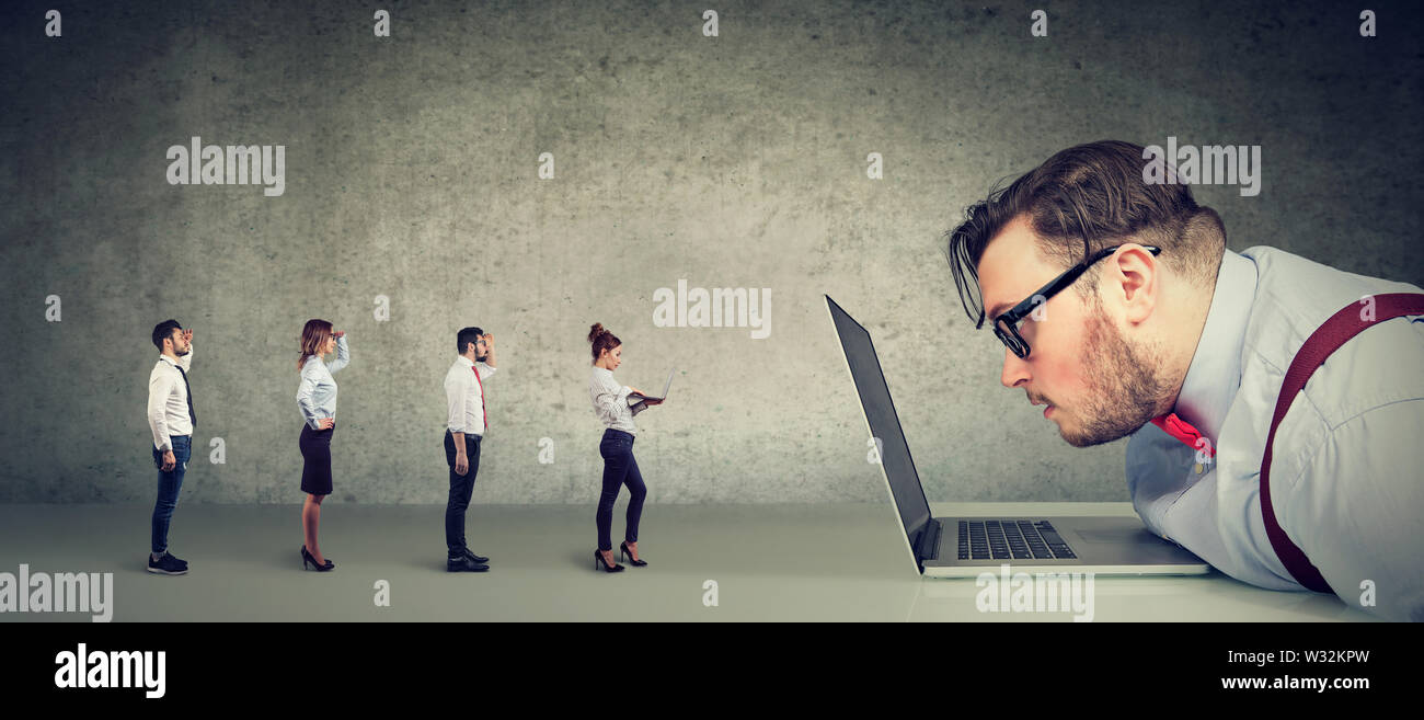 Curious businessman looking at laptop computer analyzing group of ...