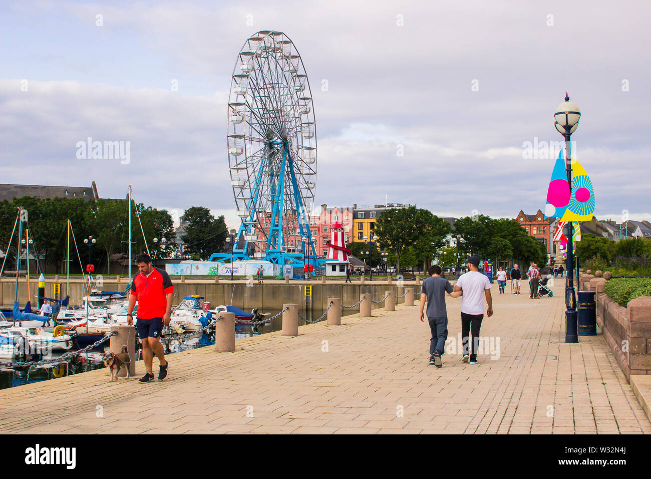 11 July 2019 pedestrians stroll the promenade at the seafront marina in ...