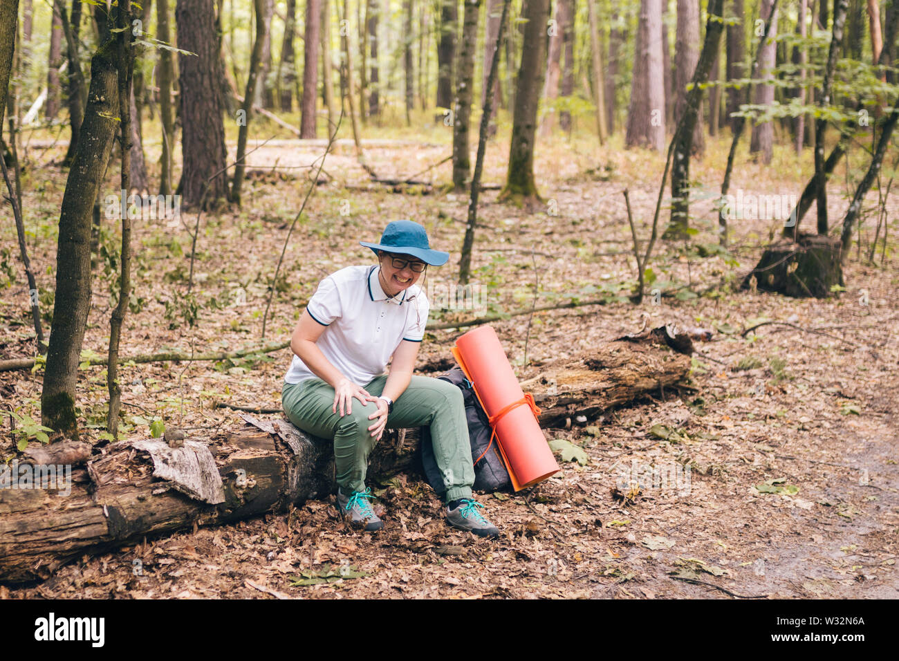 Young woman having trouble feeling knee pain during travel in forest ...